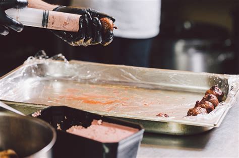 테마 요리 손을 닫습니다 부엌에서 검은 유니폼과 라텍스 장갑 젊은 백인 남자 레스토랑은 지상 쇠고기를 준비 하 고 주사기와 베리로 이어집니다 무화과 무화과 또는 카시안