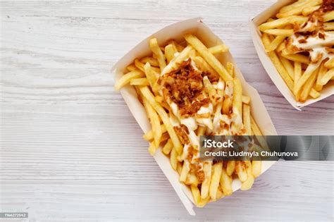 치즈 소스를 곁들인 감자 튀김과 흰 나무 배경의 종이 상자에 튀긴 양파 머리 위 전망 평면 누워 위에서 상단보기 공간을 복사합니다 프렌치 프라이에 대한 스톡 사진 및 기타