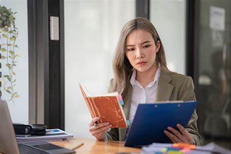 직장에서 일하는 아시아 사업가 캐주얼 정장을 입은 아름다운 아시아 여성은 책을 읽고 현대적인 사무실에서 회의나 인터뷰를 준비한다