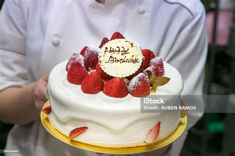 크림과 딸기로 장식 된 생일 케이크를 보여주는 여성 페이스트리 요리사 의 손 딸기에 대한 스톡 사진 및 기타 이미지 딸기