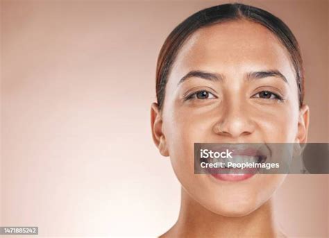 건강한 치아와 매력적인 미소로 마케팅하는 자연스러운 여성의 아름다움 초상화 및 스킨케어 화장품 광고를 위한 베이지색 스튜디오 모형 배경에 아름다운 얼굴을 가진 웰빙 모델