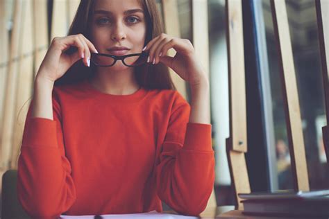 Gadis Hipster Cerdas Yang Menarik Melihat Kamera Sambil Memegang