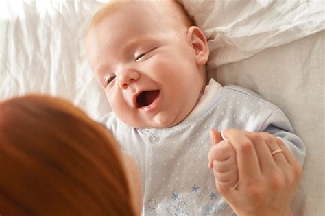 파란 침대를 입고 입 쿠 잉 또는 양치질을 하는 귀여운 아기의 수평 하이 앵글 보기 그의 엄마를 보고 아늑한 침실에서 그녀의
