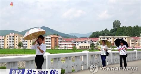 폭염 속 양산 쓴 북한 주민들