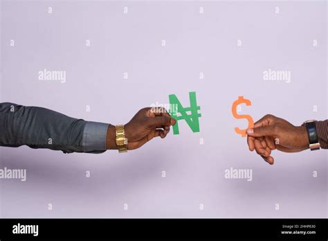 Black Men Holding Naira And Dollar Symbols Towards Each Other Stock