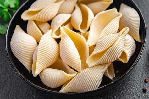 Conchiglie 파스타 생 큰 껍질 듀럼 밀 세몰라 가루 건강한 식사 음식 간식 테이블에 프리미엄 사진