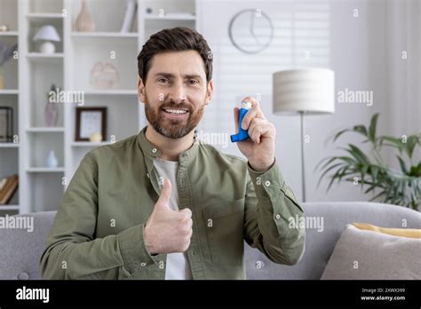Confident Man Using Asthma Inhaler While Giving Thumbs Up Conveying