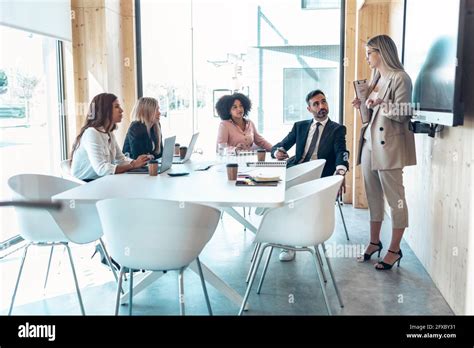 Female Entrepreneur Explaining To Multi Ethnic Coworkers In Office