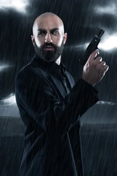Dangerous Bald Gangster Man With Beard Holding Gun Wearing Blac Stock