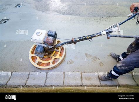 Worker Using Self Leveling Power Trowel Machine With Gas Engine Has