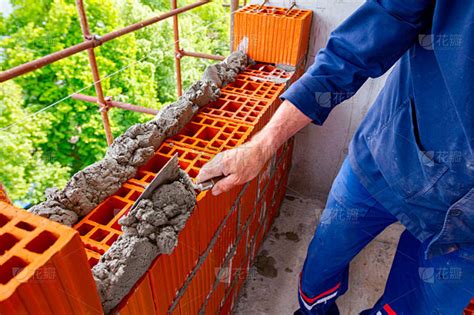建筑工用抹刀在红砖上浇筑灰泥