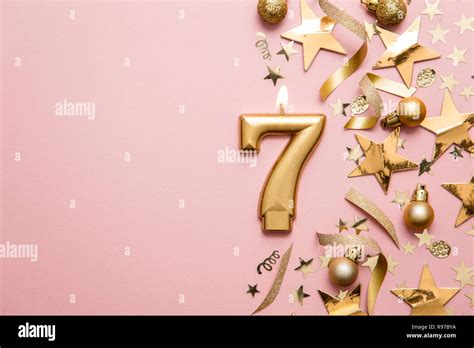 Number 7 Gold Celebration Candle On Star And Glitter Background Stock