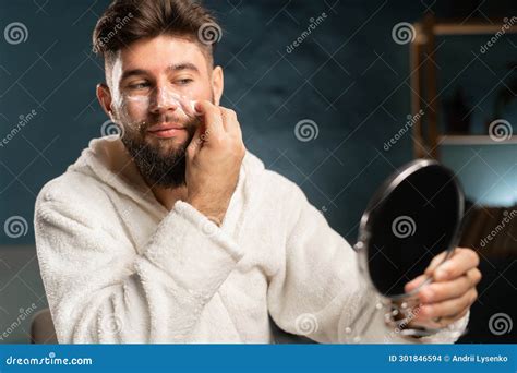 Young Man Taking Care Of His Face Putting Anti Aging Moisturizer