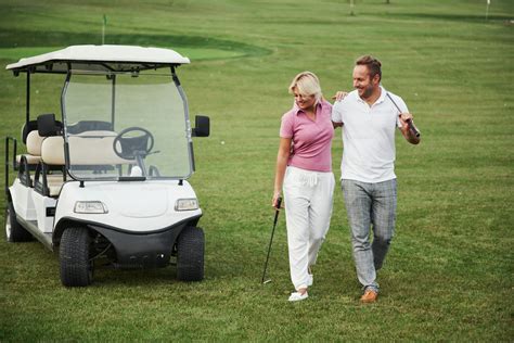두 명의 프로 골퍼 여자와 남자가 함께 다음 홀로갑니다 연인들은 포옹하고 미소 지으며 데이트를합니다 사진 Unsplash의 자동차 이미지
