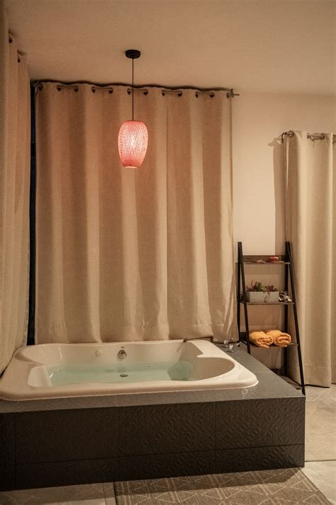 창문 옆에 대형 자쿠지 욕조가 있는 욕실 사진 Unsplash의 무료 칼빌로 이미지