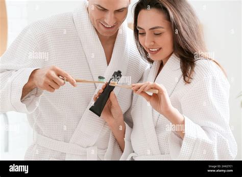 Young Couple Brushing Teeth With Activated Charcoal Tooth Paste In
