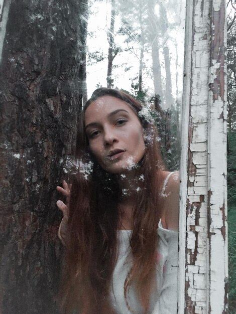 Premium Photo Portrait Of Man Standing By Tree Trunk In Forest