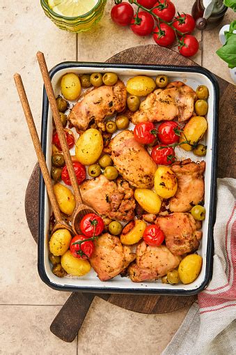 새로운 감자 방울 토마토 올리브와 함께 구운 닭 허벅지 화이트 와인 부르고뉴 스타일 소박한 베이킹 접시와 나무 배경 표지 또는 기사 평면도 텍스트의 위치 0명에 대한 스톡