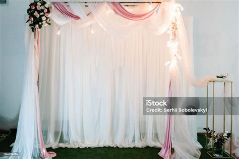 연회장에서 분홍색 꽃과 녹지의 구성으로 장식 축제 아치 사진 벽입니다 생일과 발렌타인 데이의 개념입니다 즉석 사진 촬영 부스에