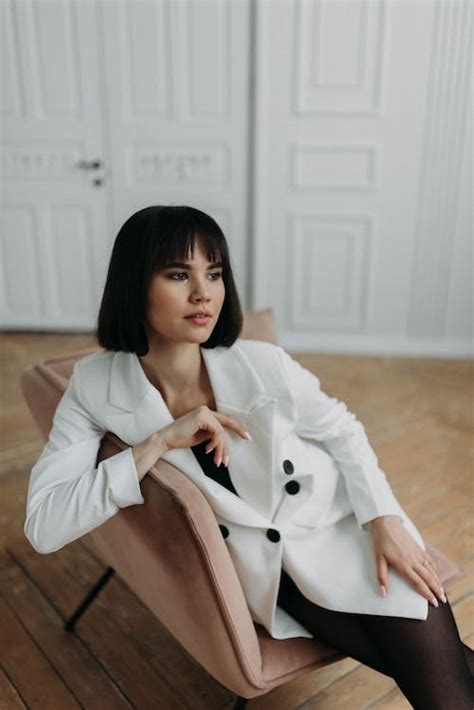 갈색 머리 모델 수직 쐈어 스타일 아름다운 안락의자 앉아 있는 여성 우아한 젊은 치마 컨템포러리 패션 포즈를 취하는에 관한 무료 스톡 사진