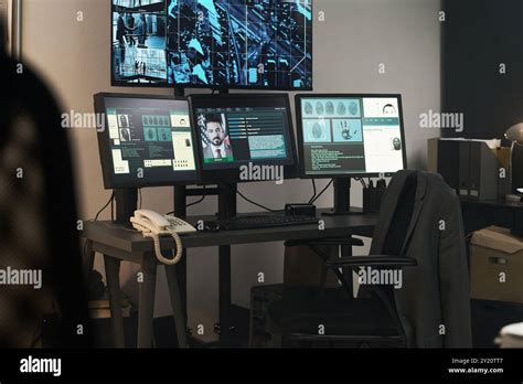 Office Space Having Multiple Computer Monitors Displaying Security Footage And Detailed