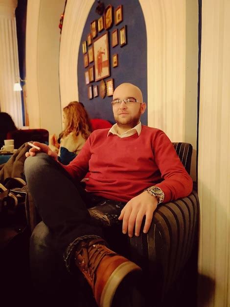 Premium Photo Portrait Of Young Man Smoking Cigarette While Sitting