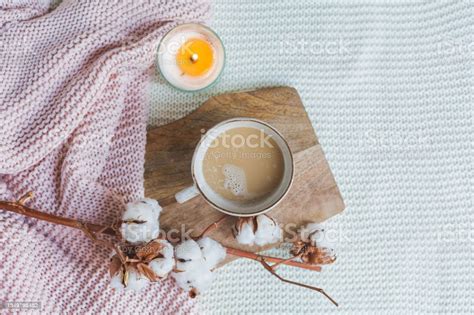 가을 플랫 평지 분홍색 니트 담요 뜨거운 카푸치노 한 잔 촛불 조명 나무 스탠드 흰색 호박 면의 가지 0명에 대한 스톡 사진 및