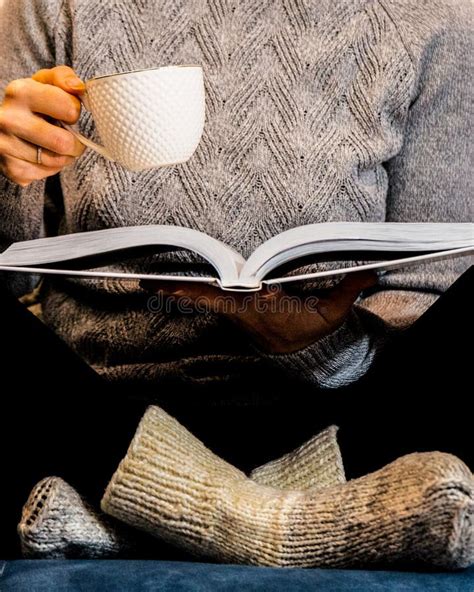 The Girl Is Sitting Cross Legged In The Lotus Position And Reading A