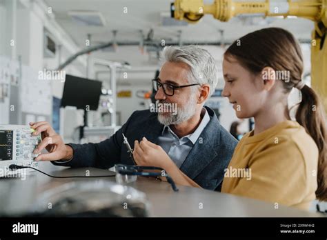 Father And Girl During Take Your Daughter To Work Day Encouraging Girl