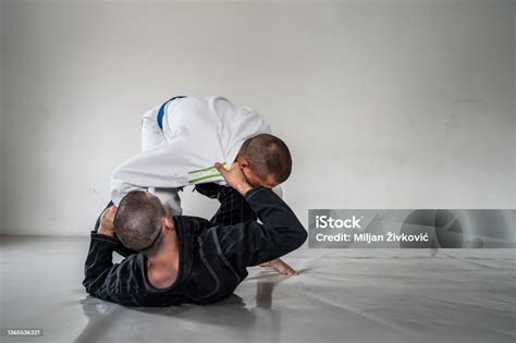 두 브라질 주짓츠 Bjj 무거티 무술 훈련 남성 선수 연습 기술 또는 검은 색과 흰색 기모노 기복을 입고 다다미 매트에