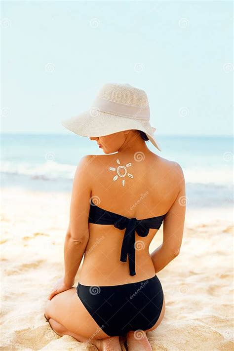 Woman Applying Sun Cream Creme On Tanned Shoulder In Form Of The Sun