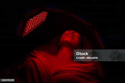 현대 미용실에서 빨간 Led 빛 얼굴 광역학 치료 치료를 받는 편안한 여성 고객의 평면도 보호 안경 환자를 입은 젊은 여자 대체 요법에 대한 스톡 사진 및 기타 이미지