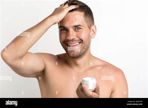 Portrait Happy Man Applying Hair Wax Standing Against White Background