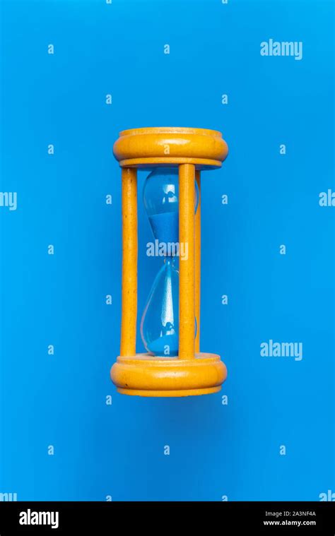 Isolated Classic Glass And Wooden Hourglass On A Color Background S