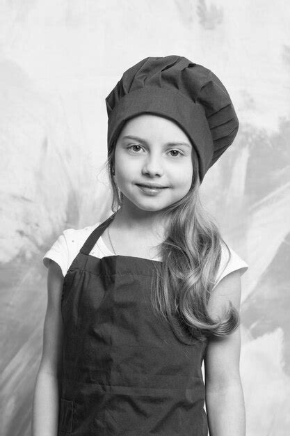 Premium Photo Small Girl Chef With Happy Face In Hat And Apron