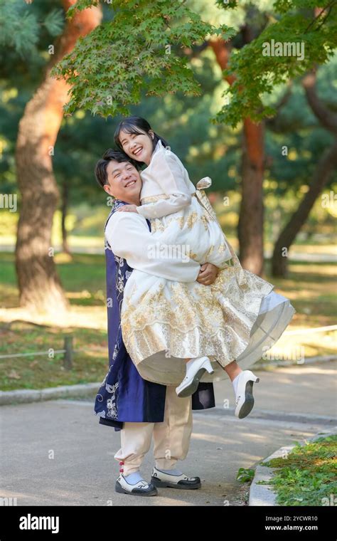 A Korean Couple A Man In His S And A Woman In Her S Are Wearing Hanbok And Hugging Each