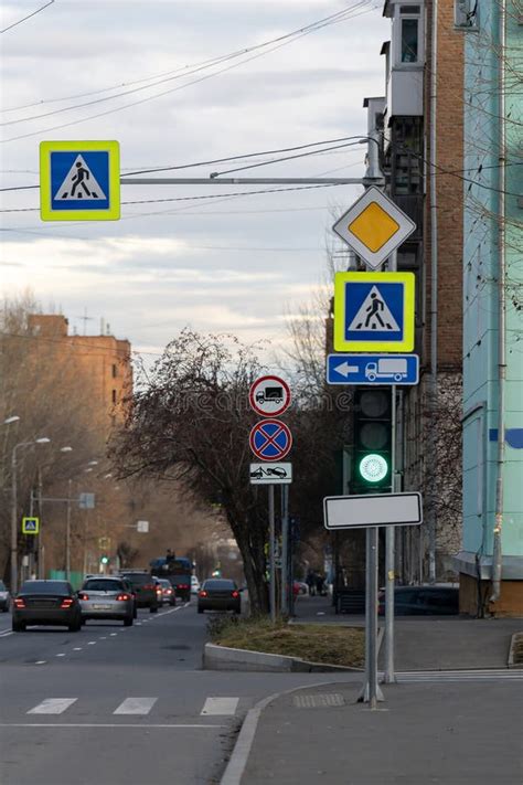 Pedestrian Crossing Signs On A Traffic Light Stand At An Intersection