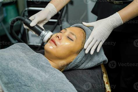 de cerca asiático belleza mujer teniendo terapia a estimular facial piel y facial ultrasónico