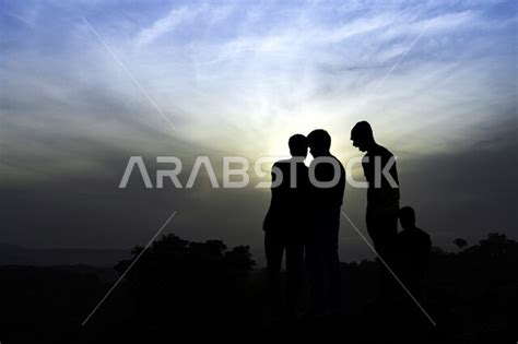 صورة ظلية لمجموعة من الأشخاص في مناطق منعزلة ، جمال منظر الشروق في سماء