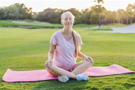 Energetic Pregnant Woman Takes Her Workout Outdoors Using An Exercise