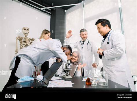 Happy Smiling Multiethnic Scientists Are Clapping Hands After