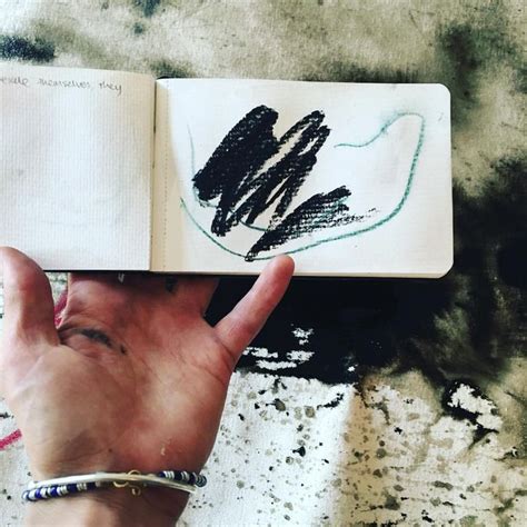 A Hand Holding An Open Book With Black Ink