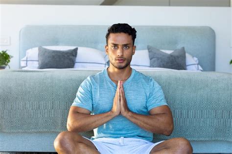 Premium Photo Portrait Of Biracial Man Sitting On Floor In Bedroom Meditating
