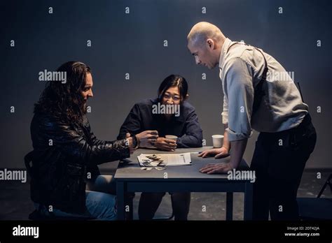 A Police Detective At The Station And His Partner An Asian Woman