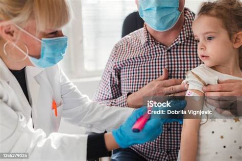 펠트 팁 펜으로 그녀의 예방 접종 상처 접착제 붕대를 색칠 하는 의사를 데 소녀 백신접종에 대한 스톡 사진 및 기타 이미지