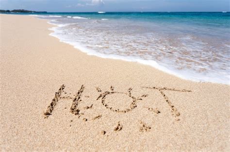 Premium Photo The Word Hot Written In The Sand On Beach