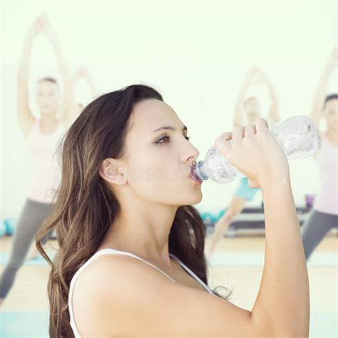 Composite Image Of Beautiful Woman Drinking Water From Bottle Stock