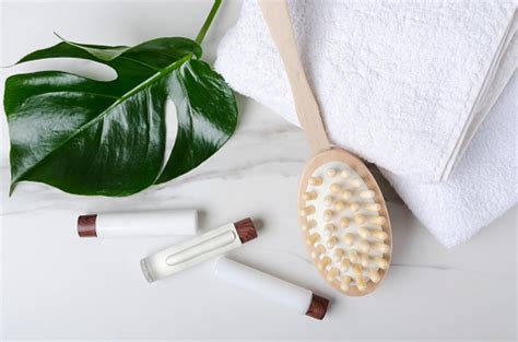 흰색 대리석 표면에 보습 제 크림 화장품 흰색 수건 바디 브러시와 녹색 잎의 병의 상단보기 건강관리와 의술에 대한 스톡 사진 및