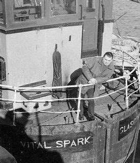 A Black And White Photo Of A Man Sitting On A Boat