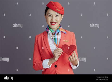 Smiling Elegant Flight Attendant Asian Woman In Red Skirt Jacket And Hat Uniform With Red Paper